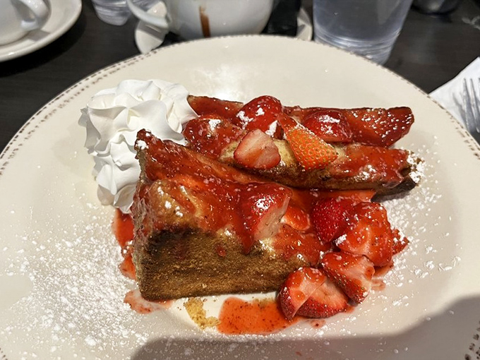 French toast topped with bacon, strawberries, and enough powdered sugar to make your dentist nervous in the best way.