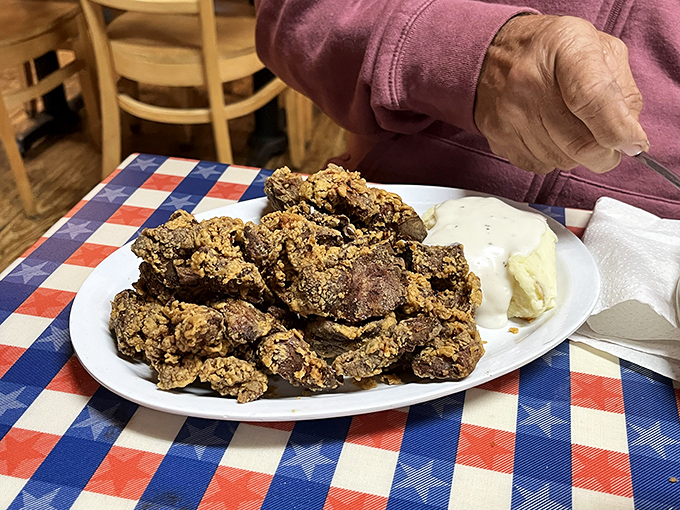 The legendary fried chicken livers in all their golden-brown glory, perfectly crispy outside and tender within, served with a side of creamy dip.