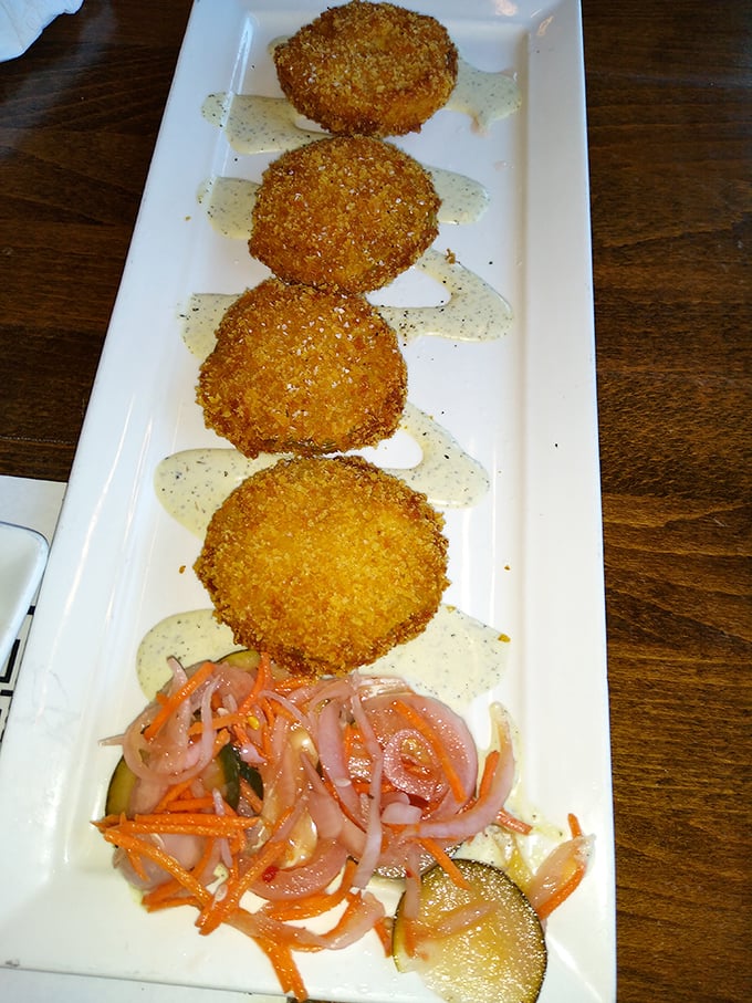 Golden-fried green tomatoes lined up like delicious soldiers, ready to battle your hunger with a tangy sauce that brings everything together.