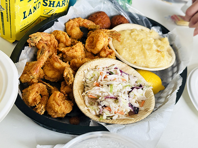 Fried shrimp perfection! Golden, crispy morsels nestled beside creamy slaw and grits—a Southern trinity that proves heaven exists on a plate.