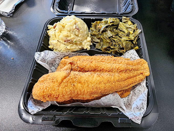 The golden-fried whiting filet stretches across the container like it's showing off, while the sides huddle nearby in delicious solidarity.