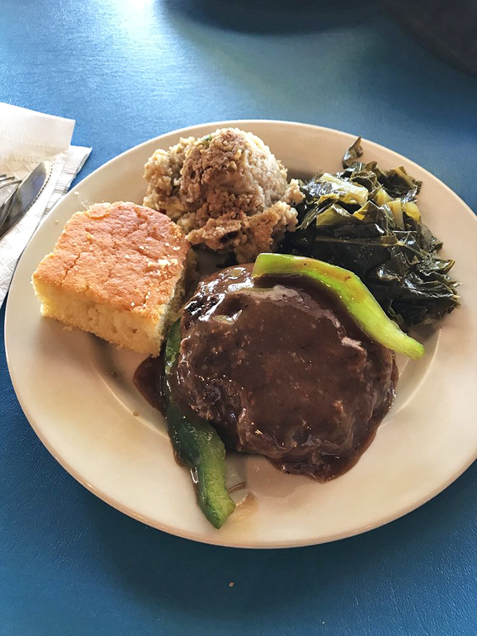 A plate that tells the story of the South&mdash;hamburger steak smothered in gravy, perfectly cooked greens, cornbread, and rice that's absorbed all the right flavors.
