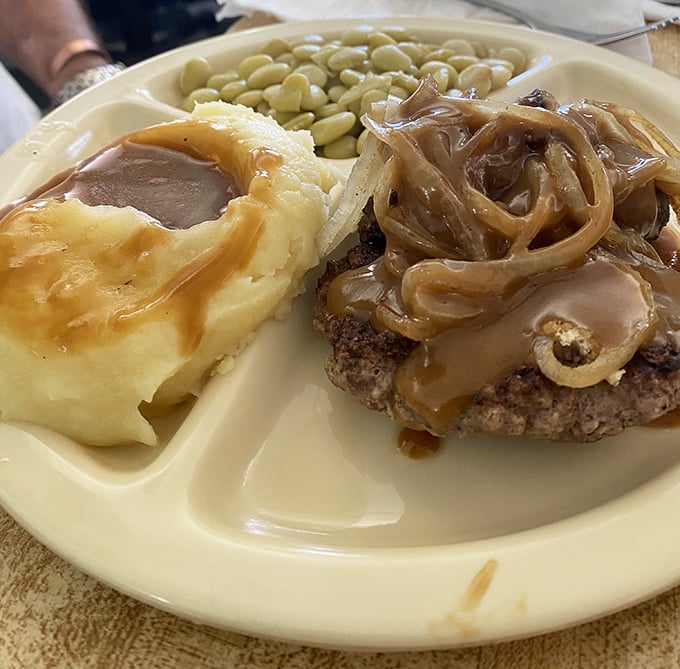 Hamburger steak smothered in caramelized onions and gravy&mdash;the kind of plate that makes you want to hug the cook afterward.