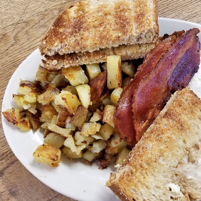 Breakfast perfection: crispy home fries, perfectly toasted bread, and bacon that would make even a vegetarian pause for consideration.