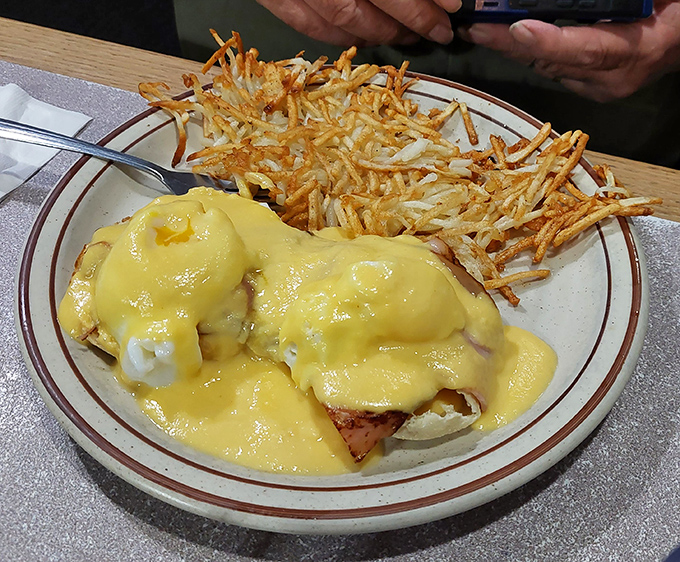 Eggs Benedict done diner-style – where the hollandaise sauce cascades like a yellow waterfall over English muffins and Canadian bacon.