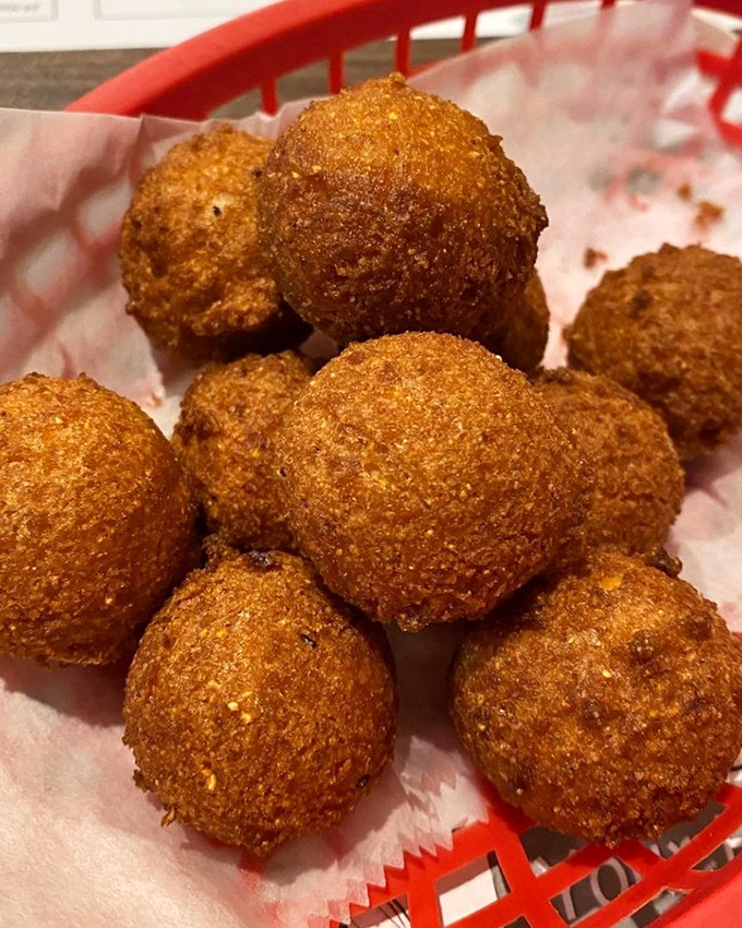 These hush puppies aren't just side dishes; they're golden orbs of cornmeal perfection that could start a family feud over who gets the last one.