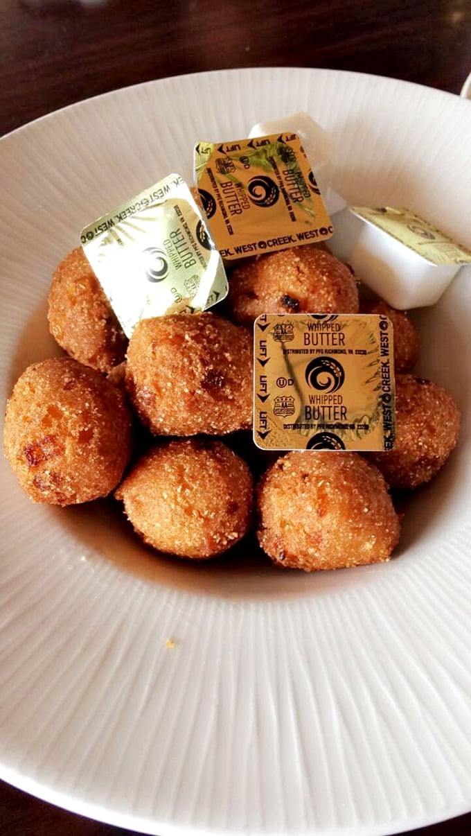 Golden-brown hush puppies that crackle with each bite, revealing a tender interior that whispers, "Yes, you absolutely need another one."