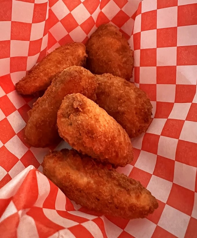 Golden-fried poppers that crunch like autumn leaves, revealing a molten cheese center that stretches dramatically with each heavenly bite.