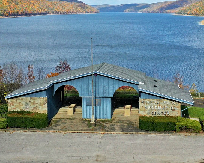 The Kinzua Point Information Center stands like a mid-century modern postcard against that impossibly blue water. Even the architecture knows it's just the opening act.