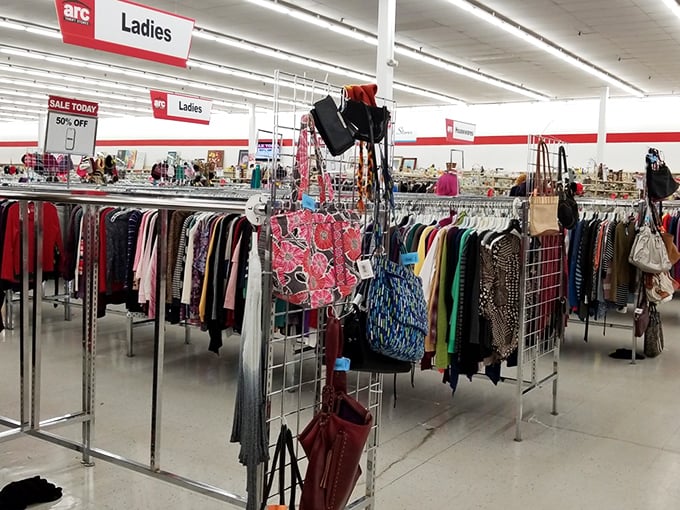 Ladies' clothing racks stand like colorful soldiers, with 50% off signs acting as commanding officers in this fashionable battle against retail prices.