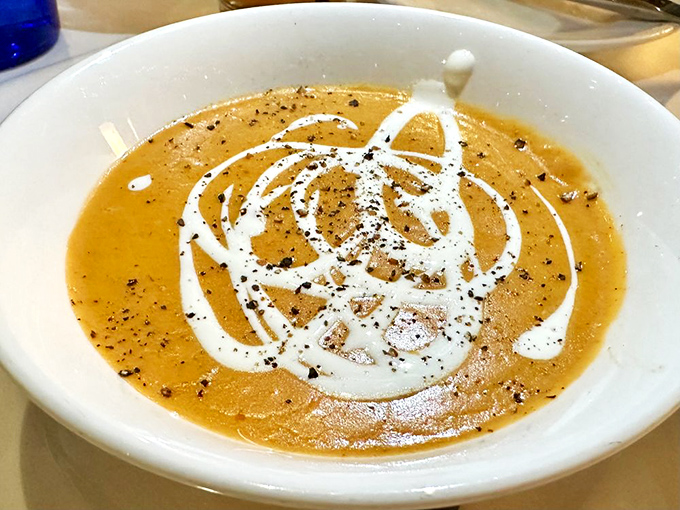 The lobster bisque arrives with artistic swirls that say, "Yes, soup can indeed be the star of the show."