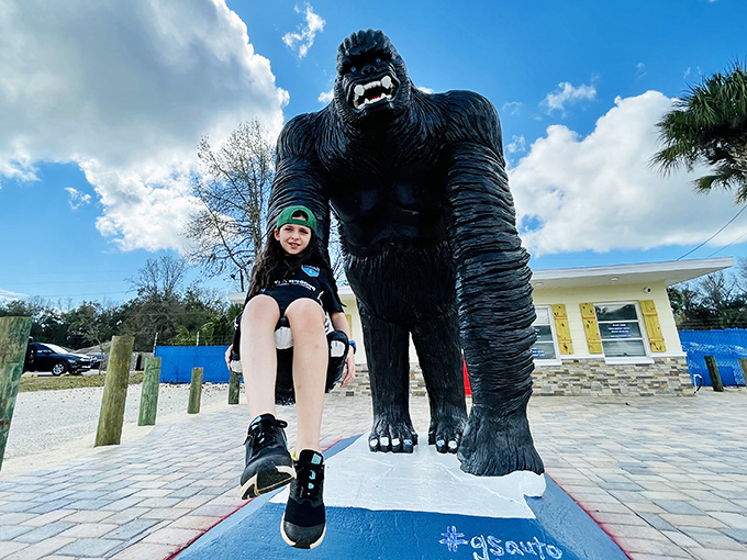 Childhood wonder meets concrete creativity as this young visitor gets the ultimate throne experience atop the gorilla's massive palm.