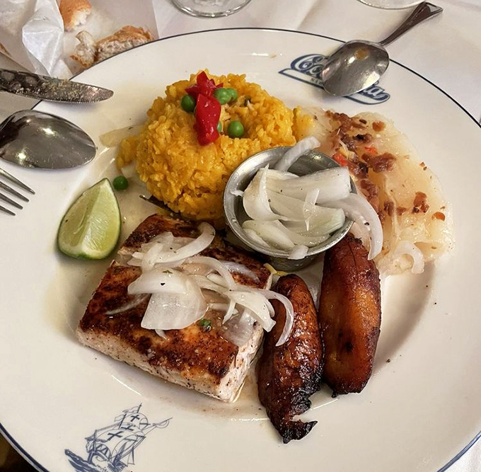 Florida meets Cuba on a plate: perfectly grilled mahi-mahi alongside yellow rice studded with peas and peppers. The lime isn't optional&mdash;it's essential.