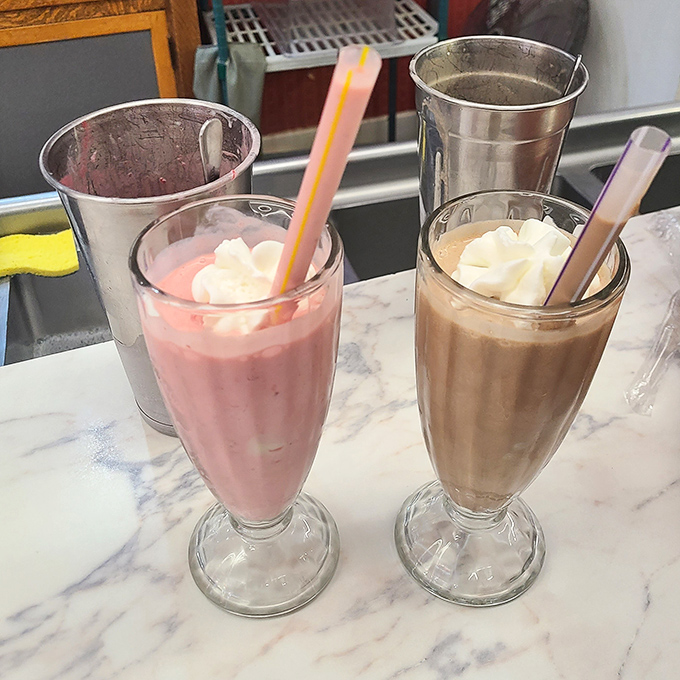 Pink and chocolate dreams standing at attention. These aren't just milkshakes&mdash;they're sculptures of dairy perfection that would make a 1950s prom date swoon.