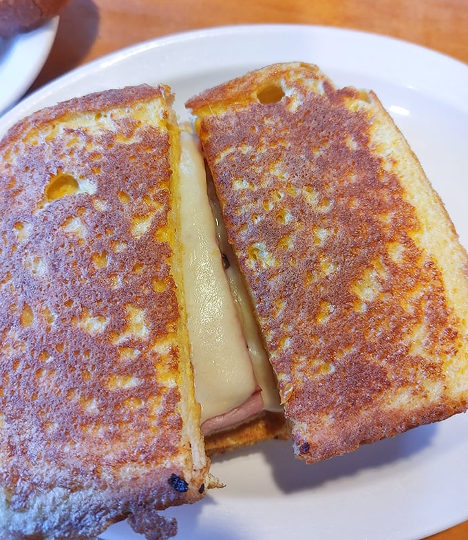 The Monte Cristo arrives golden and glorious, proving that sometimes the best sandwiches wear their French toast like haute couture.