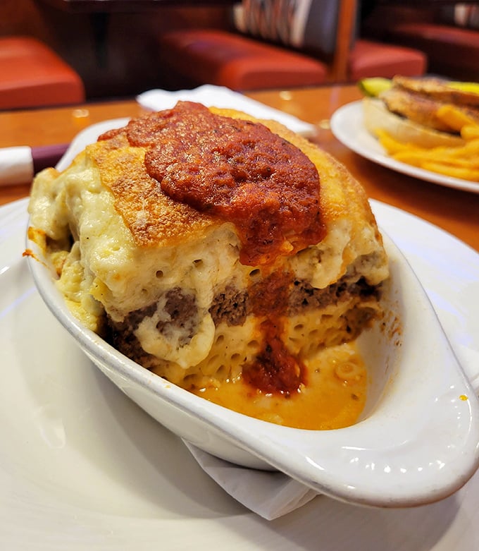 Layers of heaven! This moussaka doesn't just sit on the plate &ndash; it commands attention with its bubbling cheese and rich sauce, like the diner's edible version of a showstopper.
