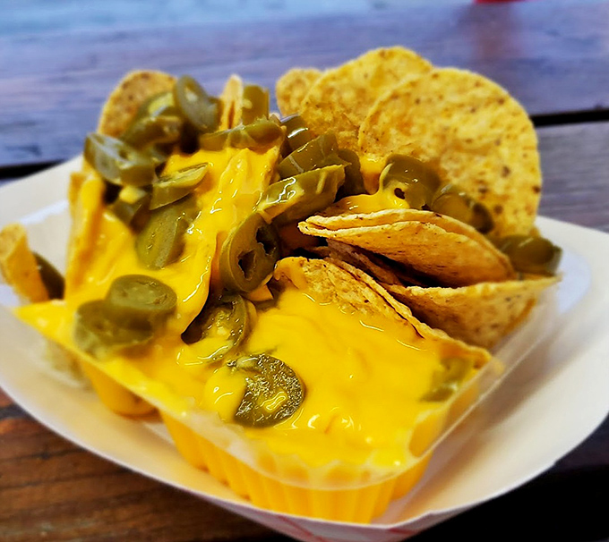 Cheese nachos that don't pretend to be fancy—just gloriously melty, topped with jalapeños that add the perfect kick to your hot dog pilgrimage.