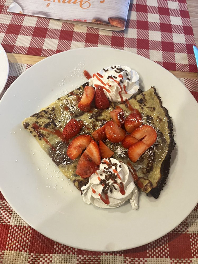 A crepe that would make Parisians nod in approval: paper-thin, perfectly browned, and adorned with fresh strawberries and clouds of whipped cream.