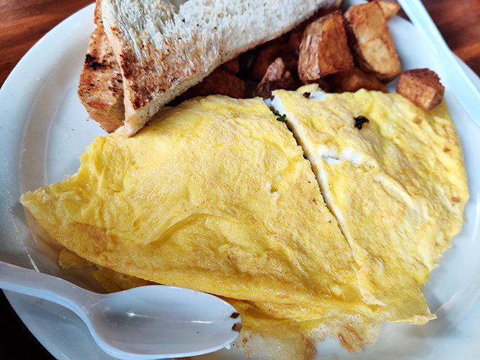 An omelet so fluffy it practically needs its own zip code, paired with home fries that make you question why you ever settled for lesser potatoes.