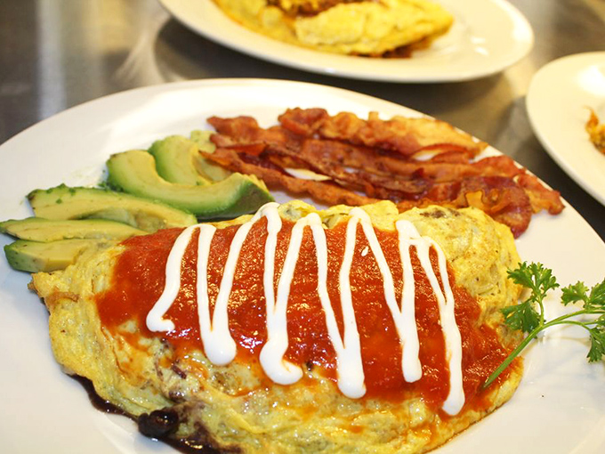 An omelet that doesn't just break eggs but breaks the mold—topped with vibrant salsa and paired with crispy bacon.