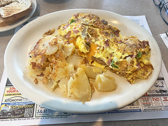 This omelet doesn't just contain ham and cheese&mdash;it celebrates them in a fluffy, golden embrace alongside home fries that deserve their own fan club.
