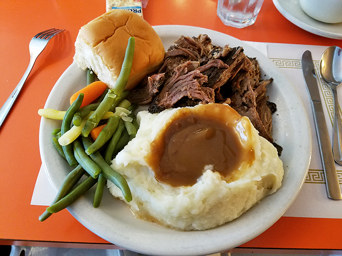The pot roast at Fred's doesn't just fall apart—it surrenders completely, nestled beside cloud-like mashed potatoes waiting for their gravy waterfall moment.