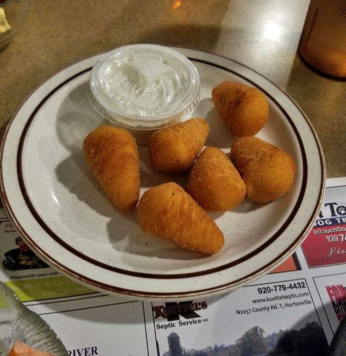 Golden potato puffs that crunch like childhood memories, served with a side of Wisconsin nostalgia and creamy dipping sauce.