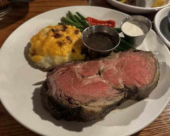 Prime rib so perfectly pink it could make a flamingo jealous, paired with a loaded potato that's having its own moment of glory.
