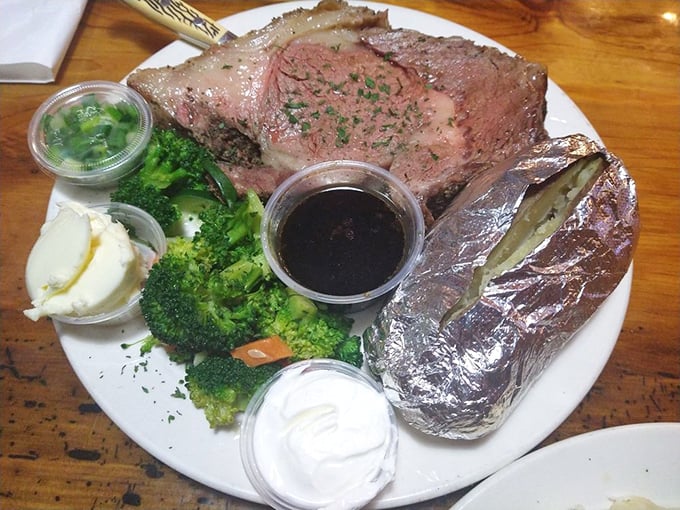 This prime rib isn't just cooked &ndash; it's been lovingly persuaded to perfection. The baked potato in foil looks like it's hiding from jealous onlookers.