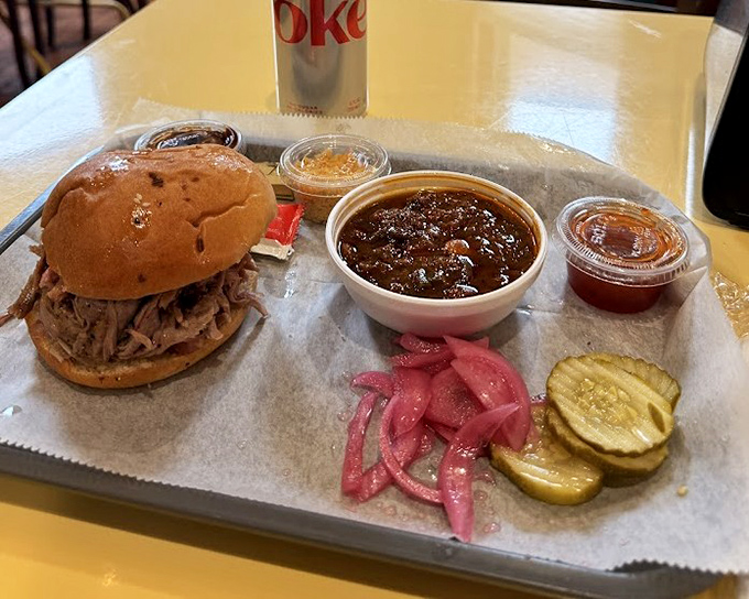 Pulled pork perfection with pickled onions that add just the right zing. That bowl of beans isn't just a side—it's a supporting actor worthy of its own award.