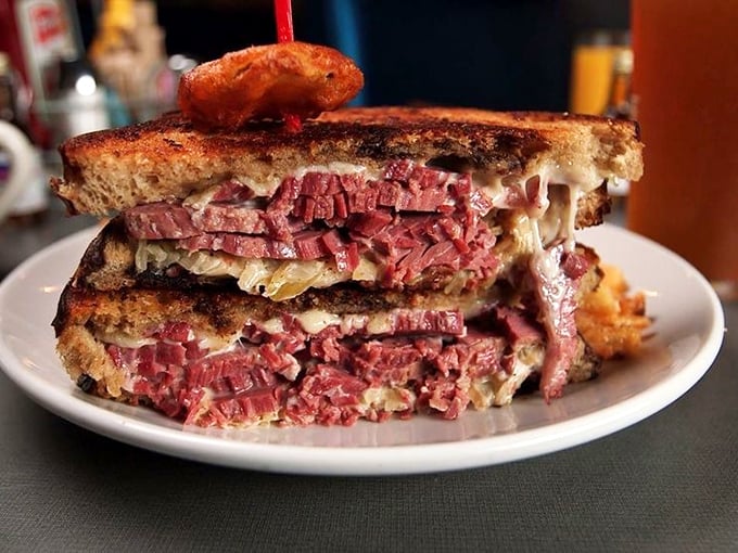 This isn't just a Reuben; it's a skyscraper of corned beef ambition. Each layer tells a story of deli perfection.