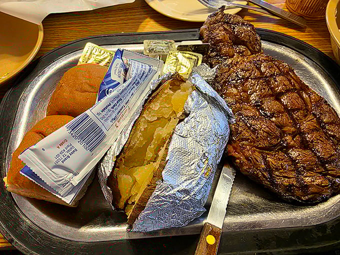 The ribeye arrives like a carnivore's dream, accompanied by a baked potato wrapped in foil like a present waiting to be unwrapped. Some meals are worth the extra napkins.