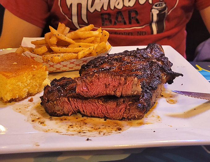 The ribeye steak arrives like a carnivore's dream painting&mdash;perfectly pink center, charred exterior, and cornbread sidekick that knows its supporting role.