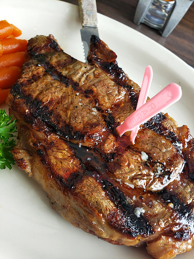 A perfectly seared ribeye that's dressed for success with those beautiful grill marks &ndash; the little pink "medium rare" marker is just a formality.