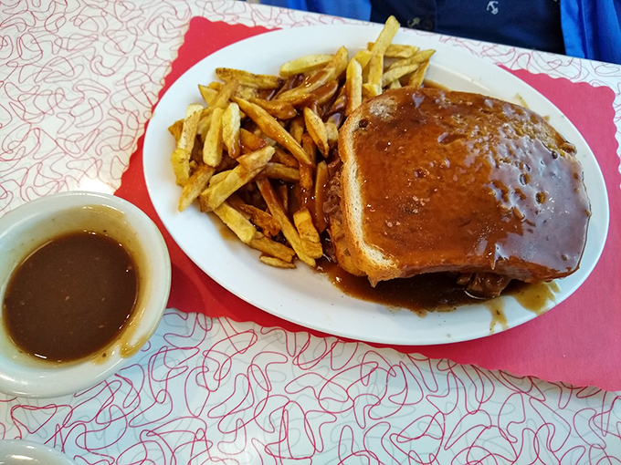 Gravy isn't just a condiment here&mdash;it's practically a religion, baptizing this hot roast beef sandwich in savory glory alongside perfectly crisp fries.