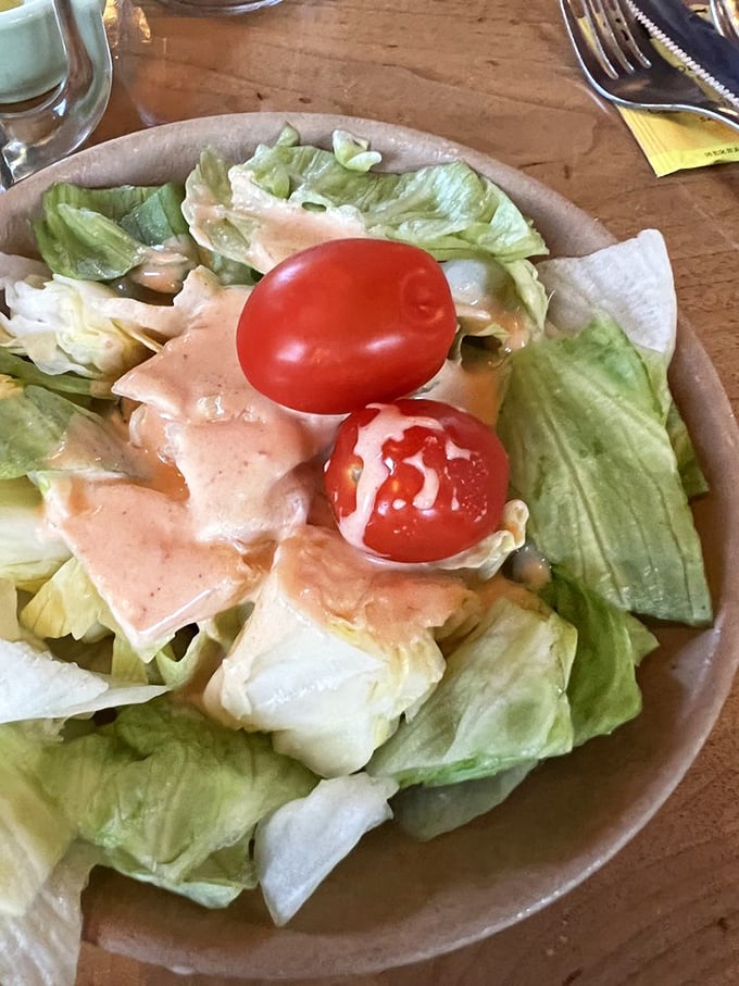 Even the salad knows its supporting role. Crisp lettuce and bright tomatoes with house dressing prepare your palate for the meaty main event.