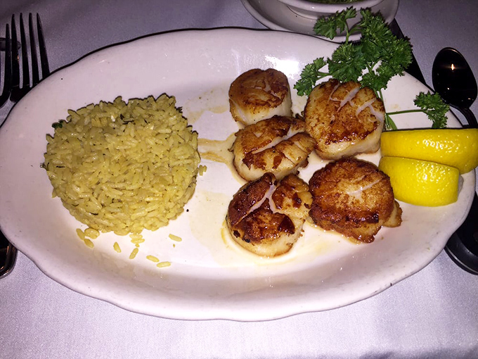 These golden-seared scallops with rice pilaf aren't just seafood&mdash;they're little ocean-flavored medallions of joy that would make Neptune himself weep with pride.