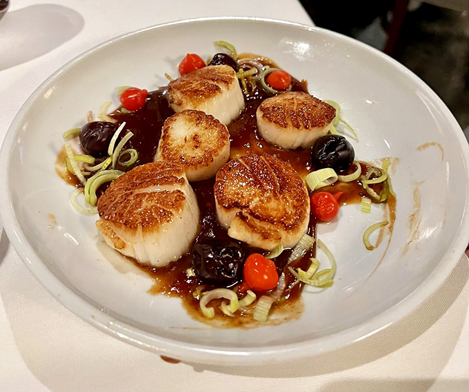 These seared scallops have achieved what we all aspire to: perfect golden exteriors while maintaining their inner tenderness. The cherry tomatoes add little bursts of sunshine.