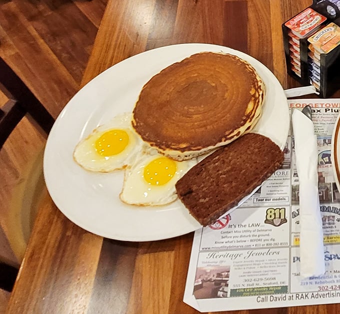 The holy trinity of breakfast: a perfectly golden pancake, sunny-side-up eggs with vibrant yolks, and scrapple&mdash;Delaware's contribution to breakfast meats everywhere.