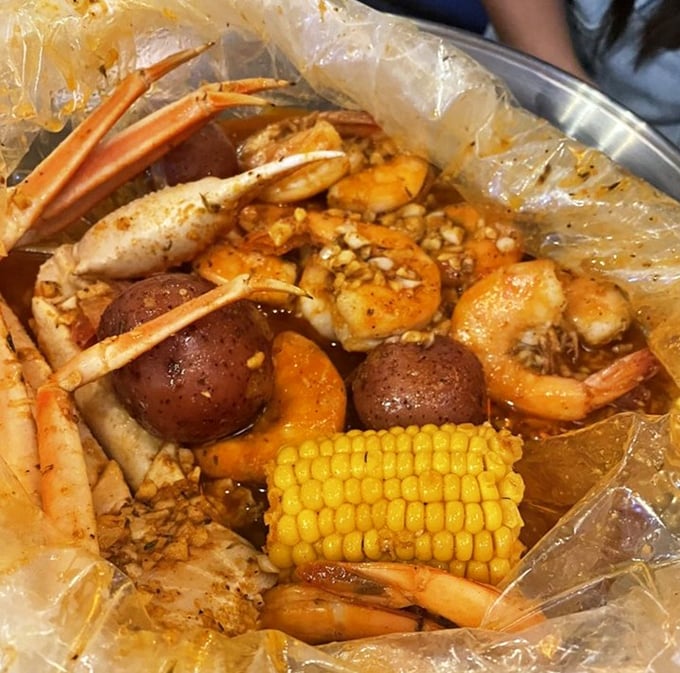 A seafood boil bag arrives like a present—crab legs, shrimp, and corn swimming in spiced butter glory.