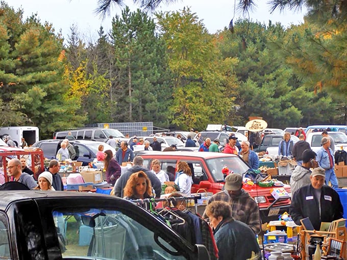 The universal dance of the flea market shuffle. Shoppers weave between vehicles and tables in the timeless ritual of finding something they never knew they needed.