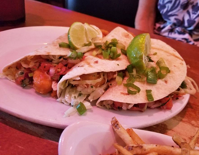 These shrimp tacos tell a coastal story with every bite—fresh, vibrant, and adorned with lime wedges like punctuation marks in a delicious sentence.