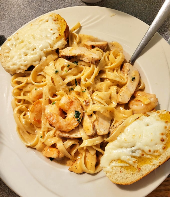 Pasta that doesn't apologize for its richness. The chicken and shrimp Alfredo comes with garlic bread that's practically begging to mop up that sauce.