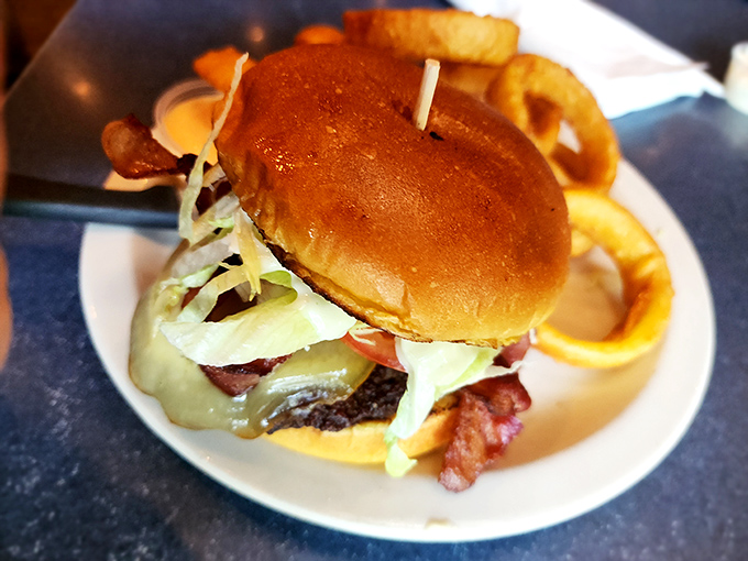 A burger that requires both hands and a strategy—melted cheese cascading down the sides like delicious lava from Mount Yum.