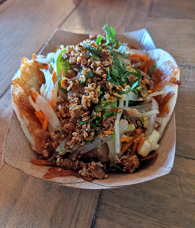 A noodle bowl that tells a story with each bite—crispy toppings, fresh herbs, and savory protein create a symphony of textures and flavors.