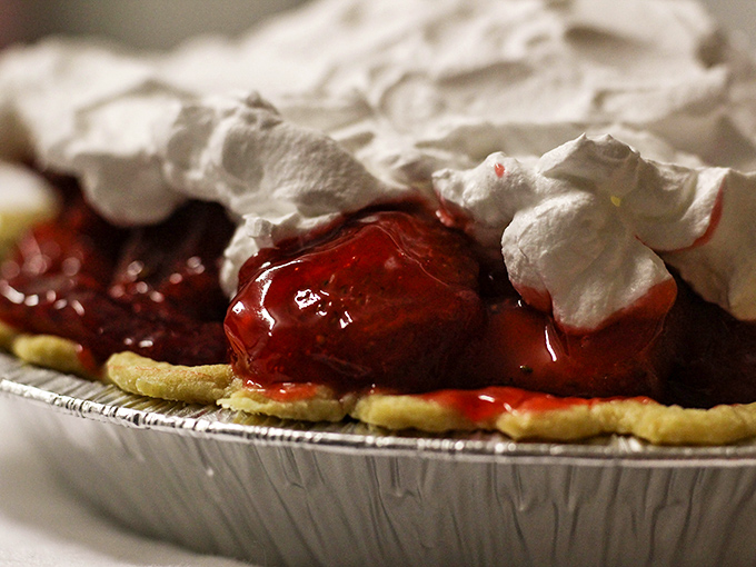 Strawberry pie that makes you question every dessert decision you've ever made. That meringue cloud floating above ruby-red filling is pure magic.
