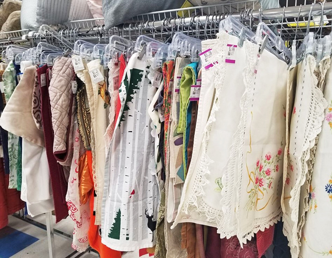 Vintage linens and delicate embroidery work hang like textile art. Someone's grandmother spent hours creating these&mdash;now they await your table.