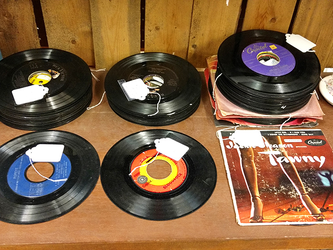 Vinyl records stacked like pancakes of musical history. Each one a time capsule of someone's road trips, first dances, and teenage rebellions.