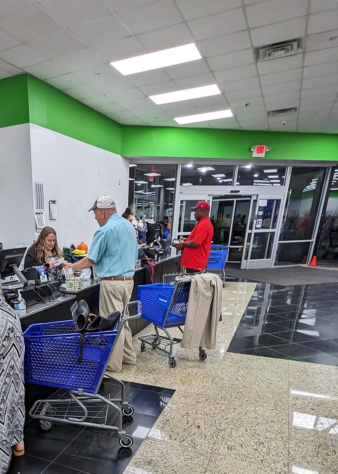 The checkout area buzzes with activity as shoppers complete their treasure hunts, blue carts filled with newfound fashion gems and household treasures.