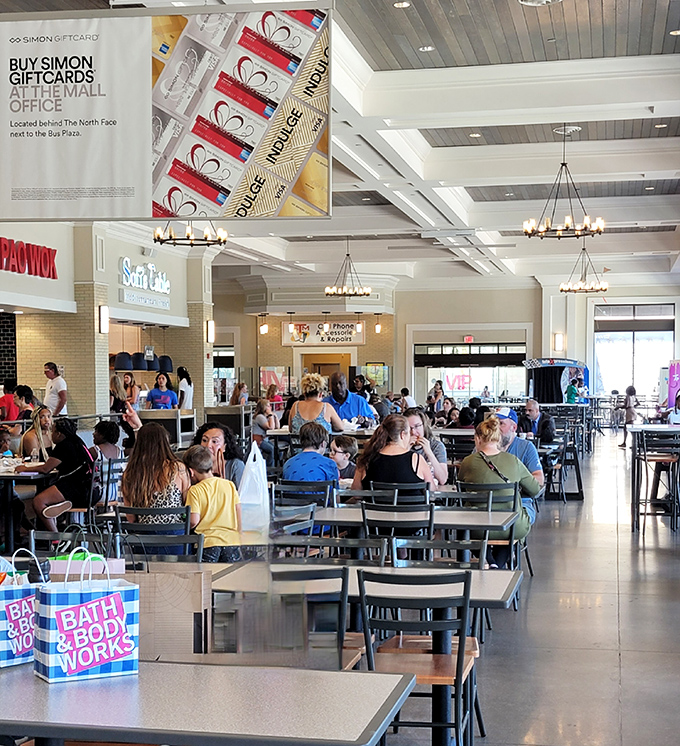 The food court buzzes with triumphant shoppers comparing their spoils while refueling for round two of retail therapy.